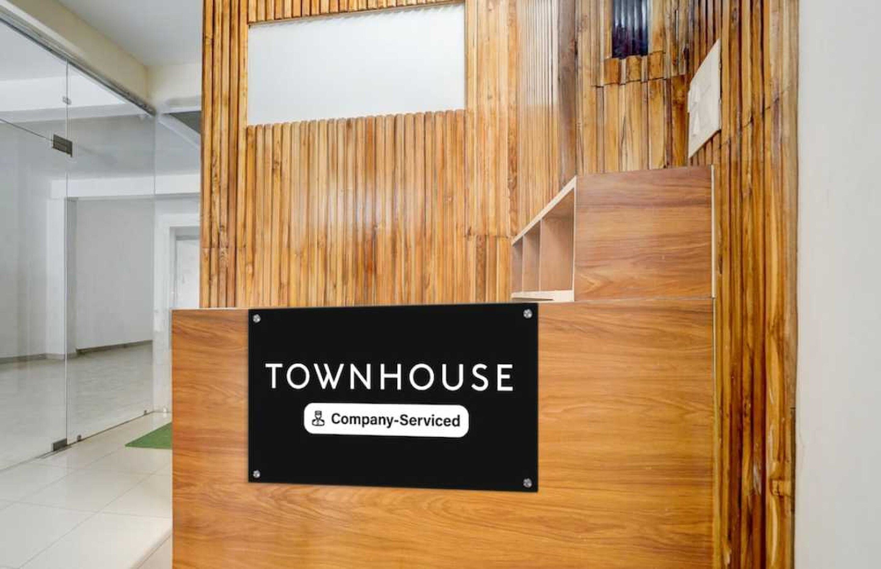Uma mesa de recepção com uma placa indicando 'TOWNHOUSE' e 'Serviço da Empresa'.