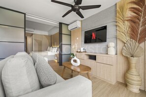 Uma sala de estar moderna com sofá, mesa de centro e televisão de tela plana na parede.