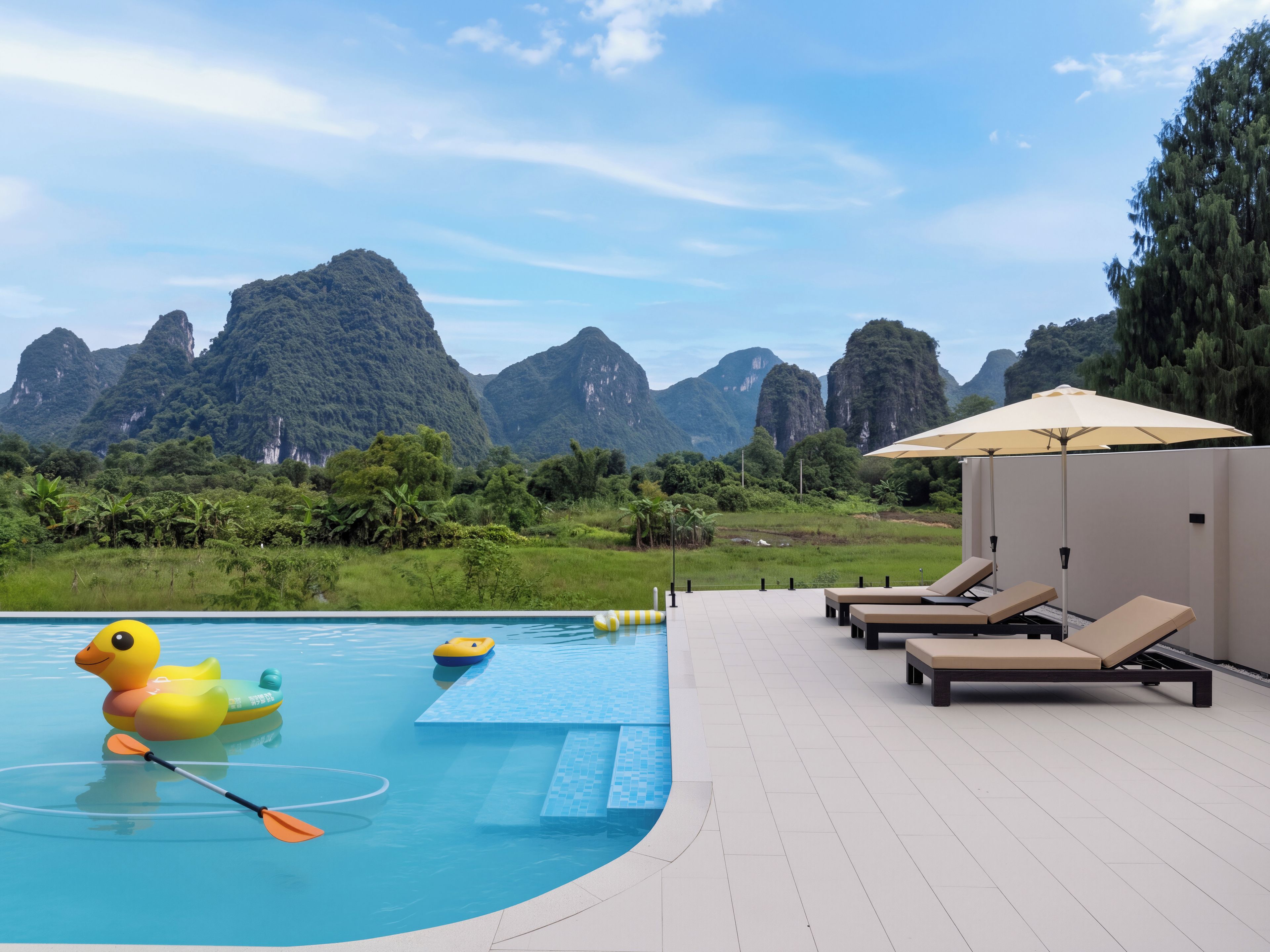 Área de piscina com espreguiçadeiras e guarda-sol, cercada por vegetação exuberante e montanhas.