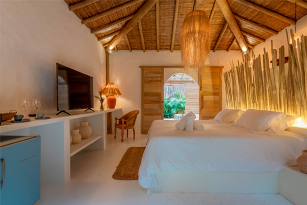 Quarto com cama, televisão, escrivaninha e janela.