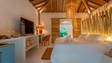 Quarto com cama, televisão, escrivaninha e janela.