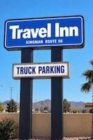Placa de Travel Inn Kingman, Rota 66, com um aviso de estacionamento para caminhões abaixo.