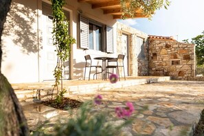Um edifício de pedra com pátio, área de estar ao ar livre e uma parede de pedra.