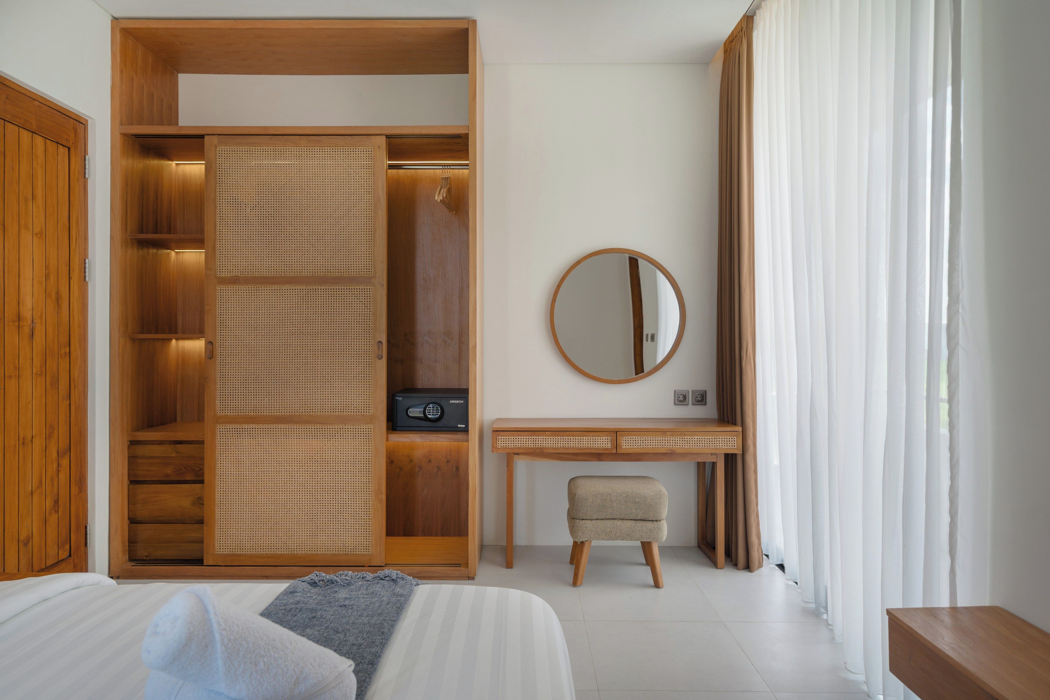 Quarto com cama, mesa de cabeceira, escrivaninha, cadeira, guarda-roupa e espelho.