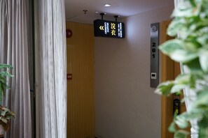 Corredor de hotel com placa indicando a lavanderia.