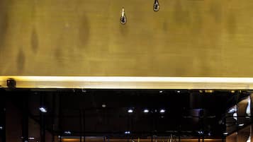 Um lobby moderno com área de estar, uma planta grande e piso estampado.