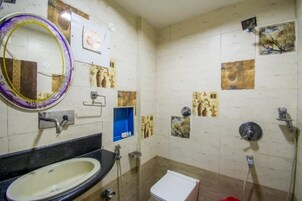 Casa de banho com lavatório, espelho e chuveiro.