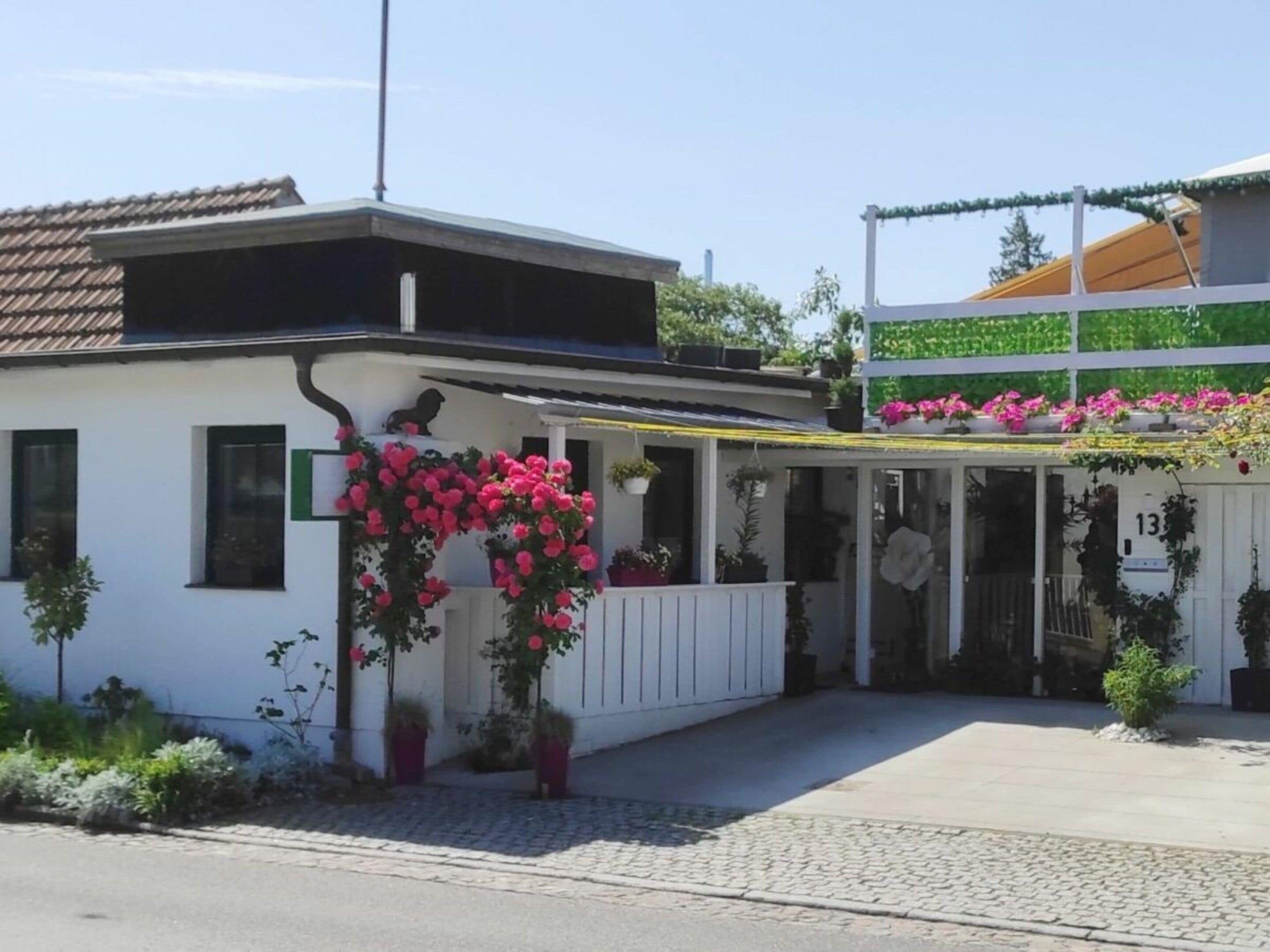 Um edifício com fachada branca, entrada coberta e placa com o número 13.