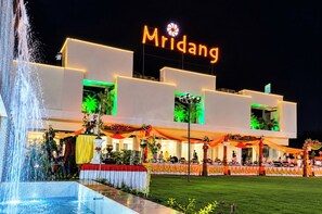 Um hotel com uma fonte, área de estar externa e uma placa que diz 'Mridang'.