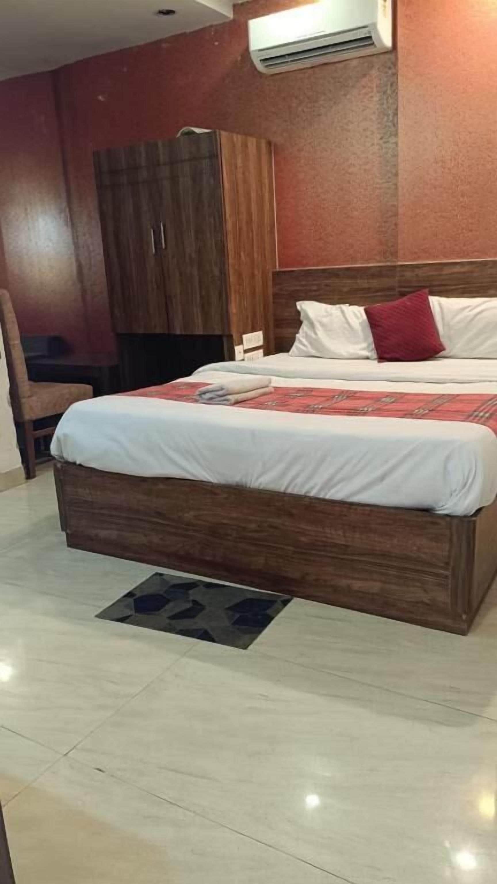 Quarto de hotel com uma cama grande, um guarda-roupa e uma escrivaninha.
