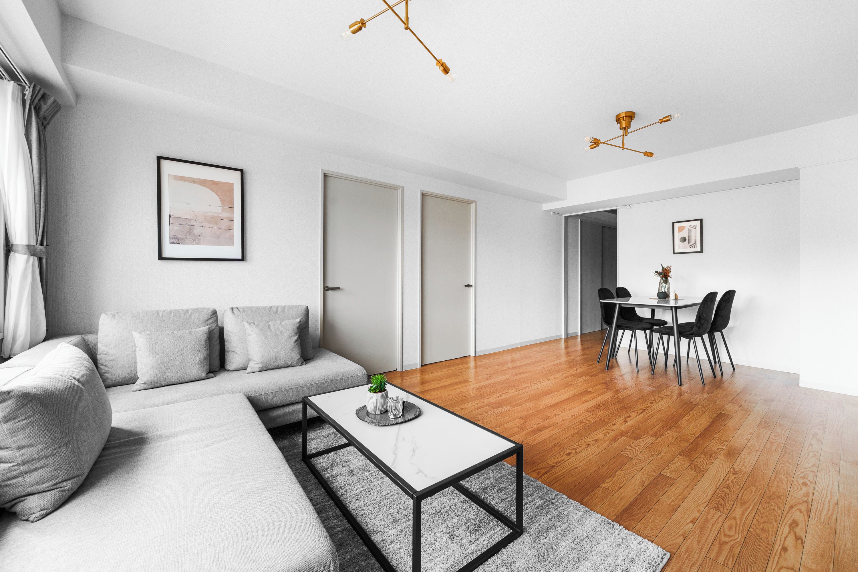 Uma sala de estar moderna com sofá, mesa de centro e área de jantar.