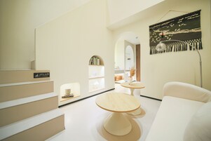 Um interior moderno com escada, uma mesa redonda e um sofá.