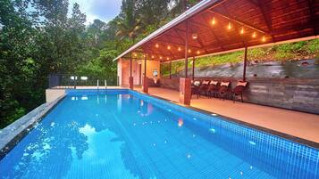 Piscina com área coberta e espreguiçadeiras.