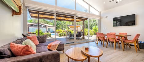 Uma sala de estar moderna com sofá, mesa de centro e área de jantar com cadeiras.