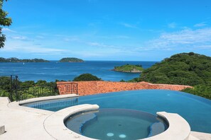 Piscina infinita com vista desobstruída do mar e ilhas ao longe.