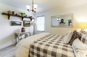 Quarto com cama, mesa de cabeceira, penteadeira e espelho.