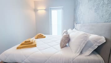 Quarto de hotel com cama, travesseiros e janela.