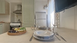 Uma cozinha com fogão, chaleira e uma cesta de frutas no balcão.