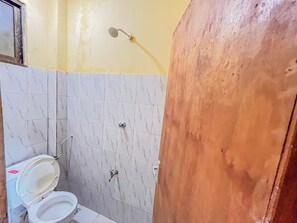 Casa de banho com sanita, chuveiro e lavatório.