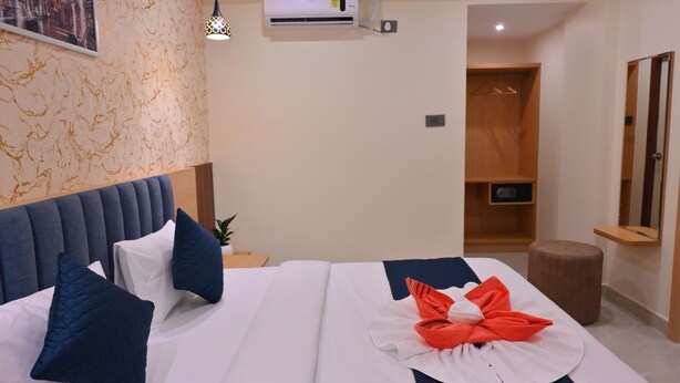 Quarto de hotel com cama, mesa de cabeceira, guarda-roupa e ar condicionado.