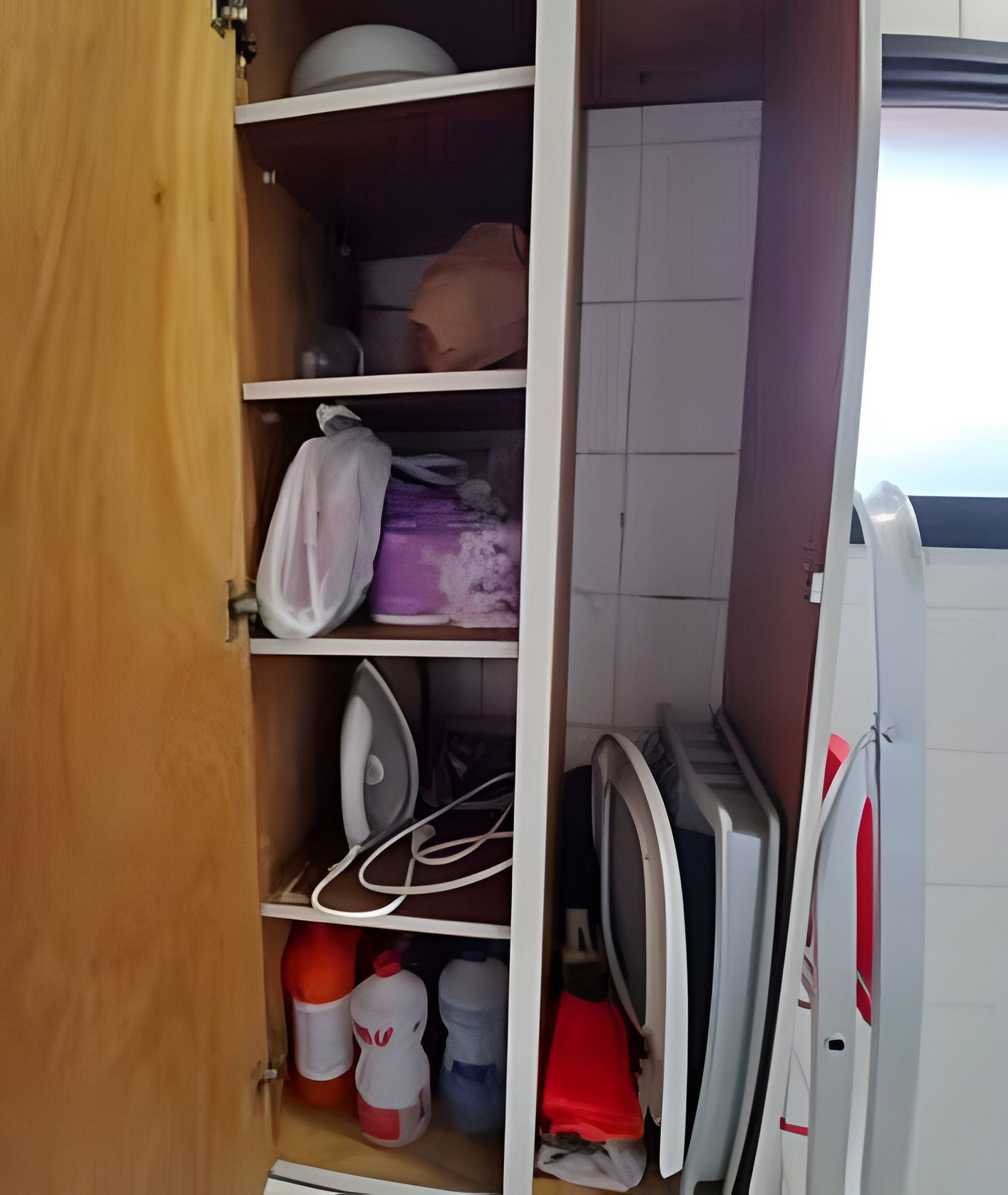 Cozinha com armários brancos, micro-ondas e geladeira.