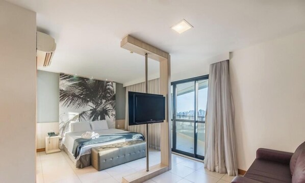 Quarto de hotel moderno com cama, TV de tela plana, janela grande e varanda.