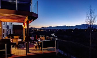 Um terraço com área de estar ao ar livre e vista para uma paisagem montanhosa.