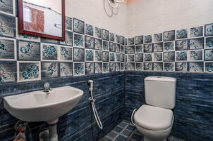Casa de banho com lavatório, sanita e azulejos decorativos.
