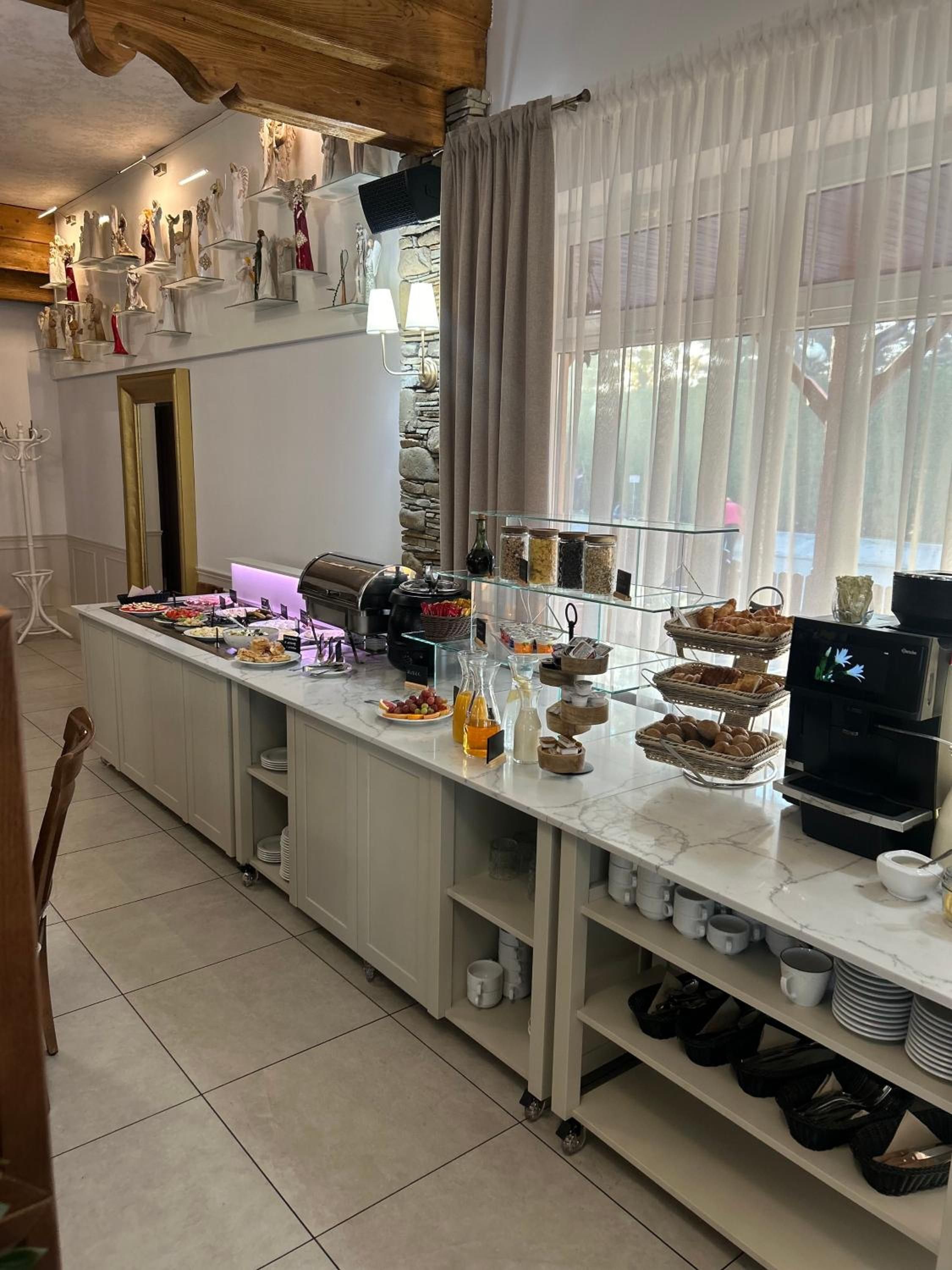 Disposição de buffet com diversos alimentos e uma máquina de café.