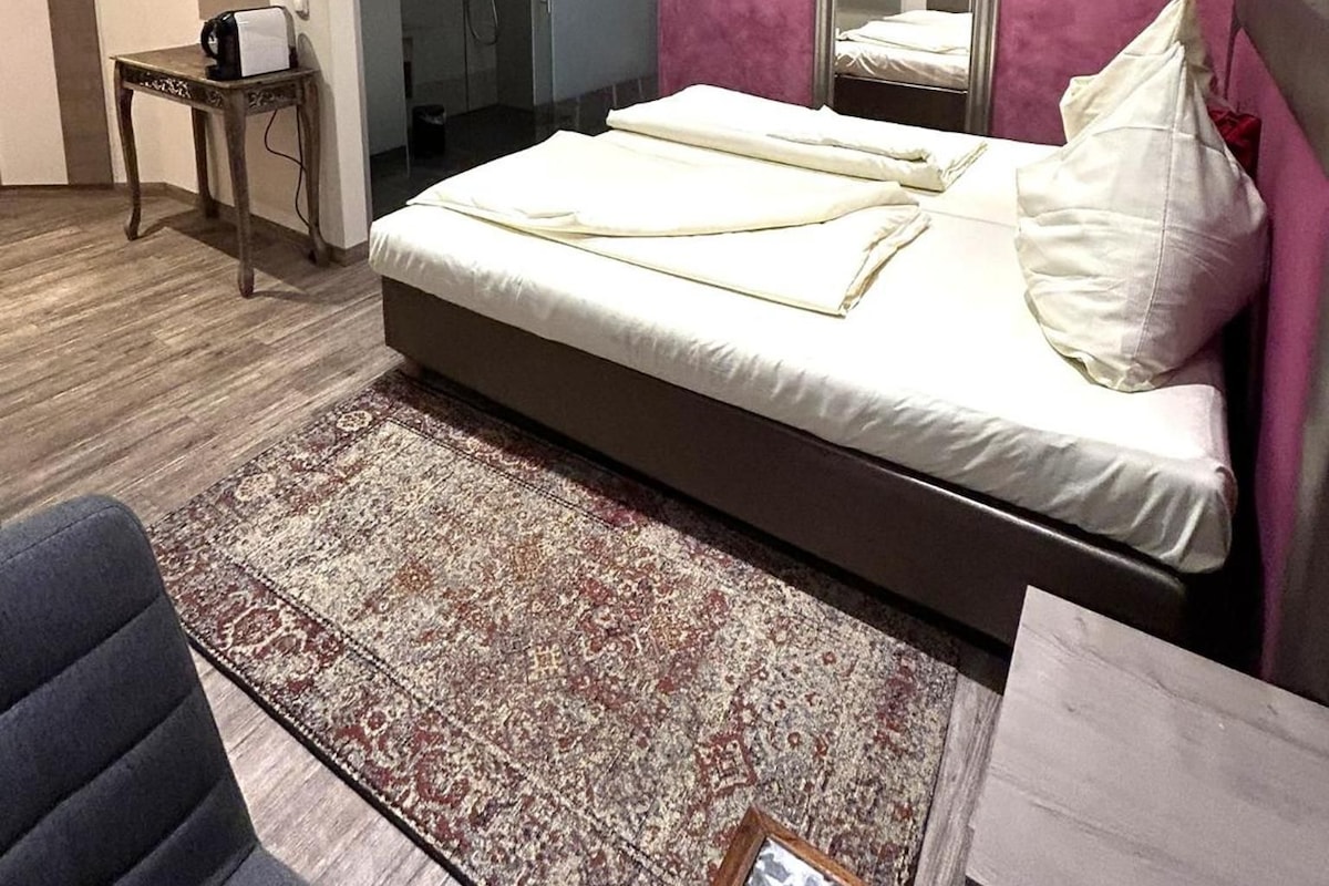 Um quarto moderno com cama, espelho, escrivaninha e closet espaçoso.