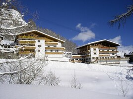 Um hotel com vários andares, restaurante e teleférico em uma região montanhosa coberta de neve.