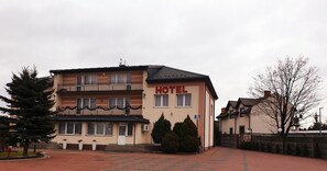 Um hotel com estrutura em dois andares, uma varanda no andar superior e uma placa indicando o número 70.