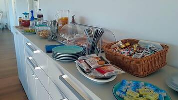 Disposição de buffet com diversos alimentos e utensílios.