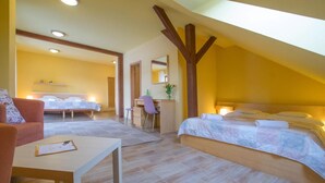Quarto com cama, escrivaninha, cadeira e sofá.