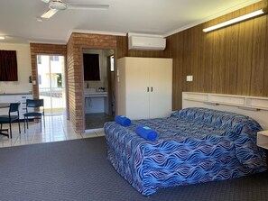 Um quarto com cama, guarda-roupa, escrivaninha e cadeira.