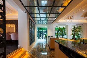 Um interior moderno com cozinha, área de refeições e corredor que leva a uma estufa.