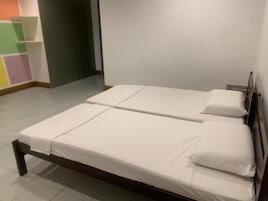Uma cama de casal com roupa de cama branca num quarto de hotel.