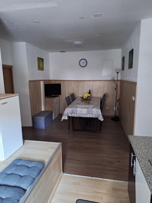 Espaço compacto com área de jantar, cozinha compacta e um pequeno espaço para sentar.