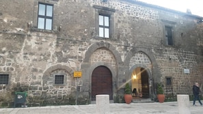 Um edifício histórico de pedra com portas em arco e uma entrada central.