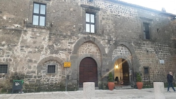 Um edifício histórico de pedra com portas em arco e uma entrada central.