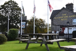 Hotel Llandewdd Arms com área externa para sentar e bandeiras.