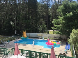 Quintal com piscina, escorrega e brinquedos infláveis.