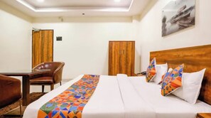 Quarto de hotel com cama, escrivaninha, cadeira e dois guarda-roupas.