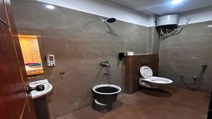 Casa de banho moderna com sanita, bidé e chuveiro.