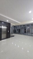 Um hall amplo com elevador moderno e paredes de vidro.