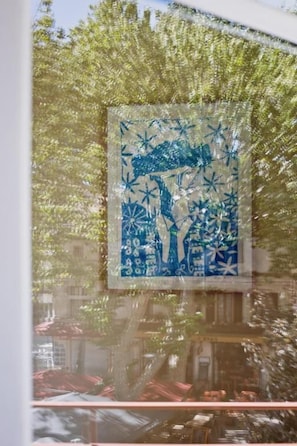 Janela com arte azul retratando uma árvore e flocos de neve.
