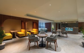 Uma área de estar moderna com assentos, um bar e vista para o exterior.