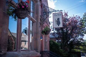 Um edifício com uma placa indicando 'The Bear Tattenhall' e uma silhueta de urso.