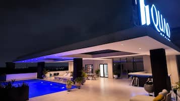 Um hotel moderno com piscina, área de estar ao ar livre e bar.
