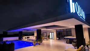 Um hotel moderno com piscina, área de estar ao ar livre e bar.